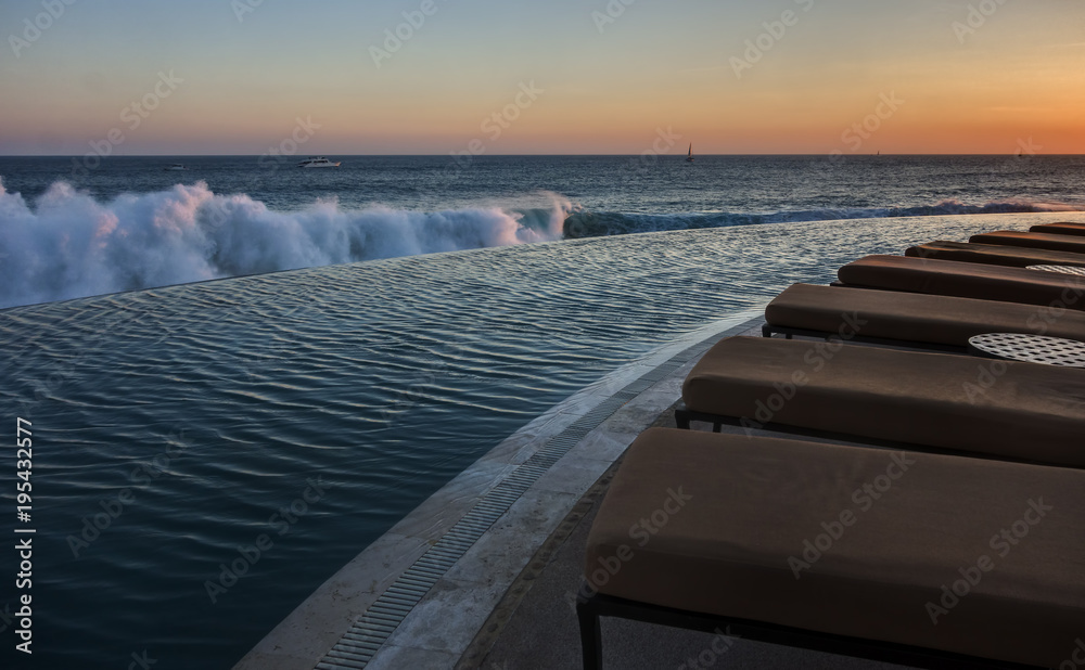 Lounge Chairs by an Infinity Pool Overlook the Crashing Waves of the ...