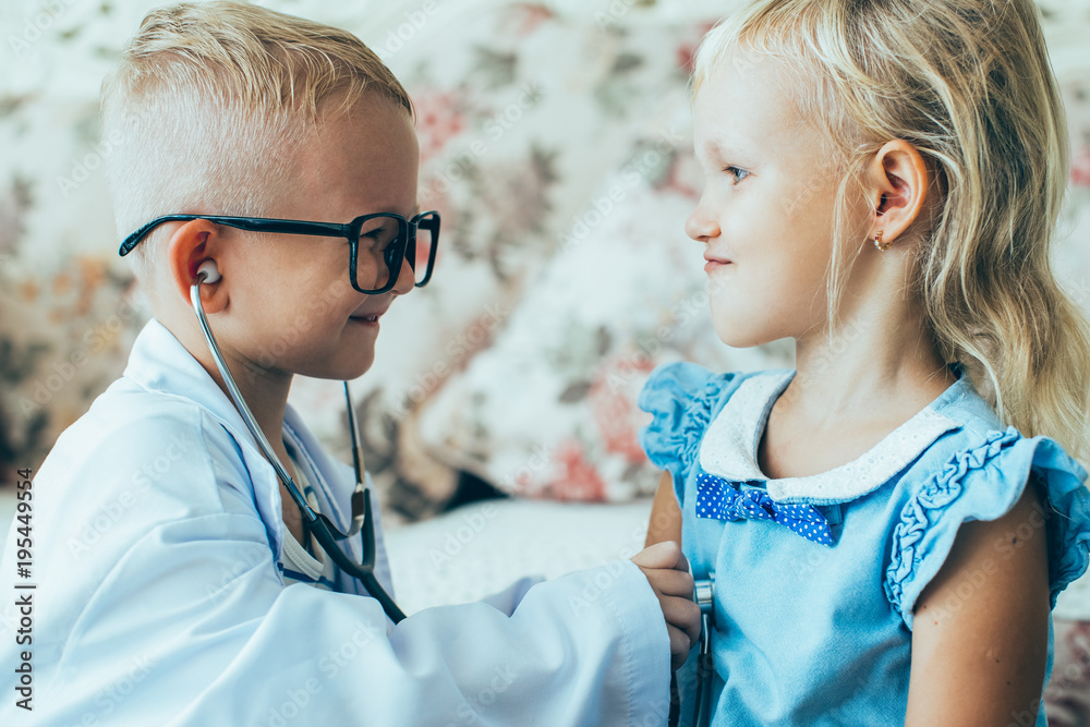 Happy little children playing doctor and patient Stock Photo | Adobe Stock