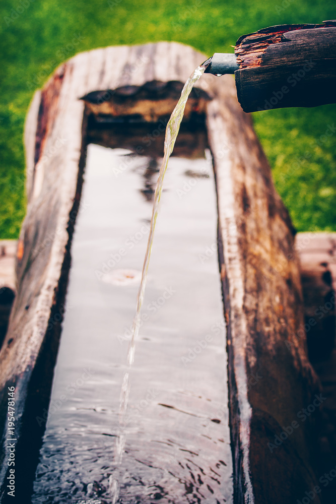 Water pipe with fresh water streaming into the wooden washtub. Typical ...