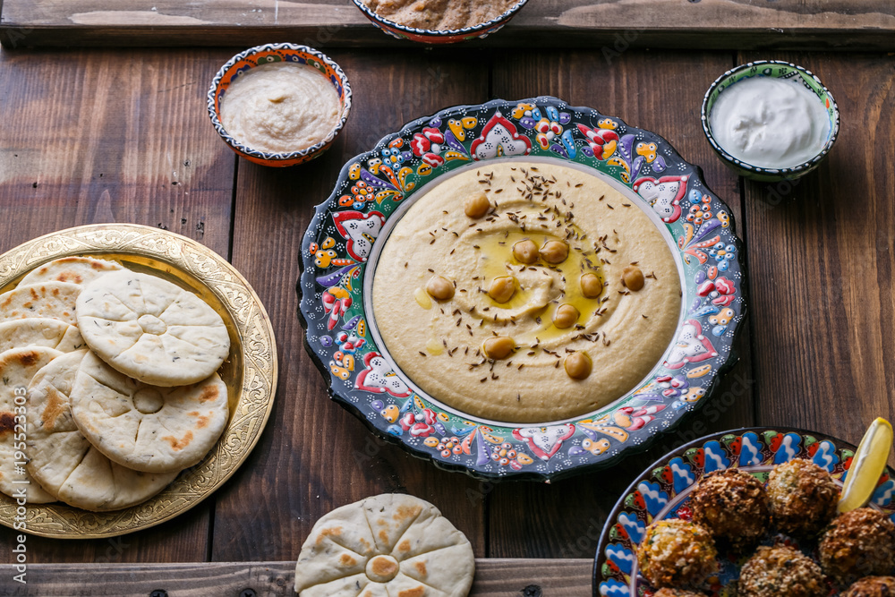 Hummus, chickpea, falafel with tahini, yoghurt and pita in traditional ...