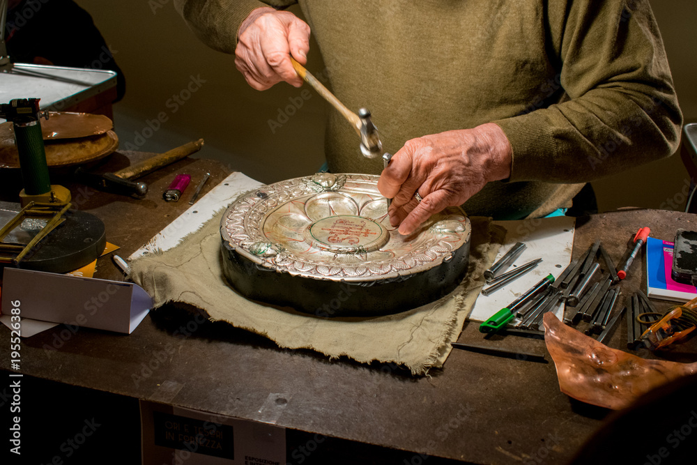 the process of making decorative dishes of metal( silver), hands of the ...