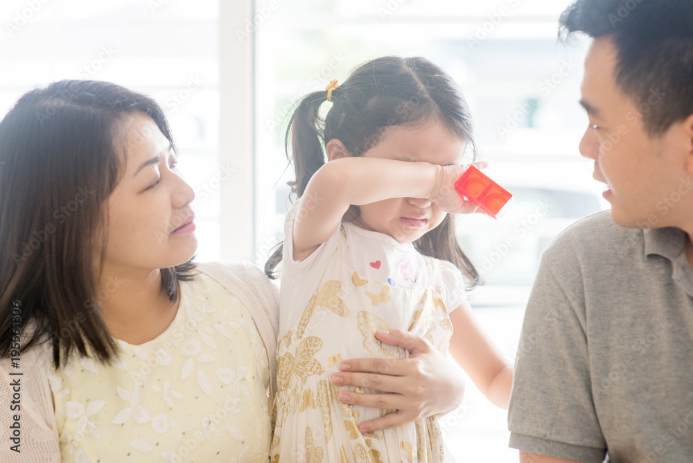 Parents comforting crying child Stock Photo | Adobe Stock