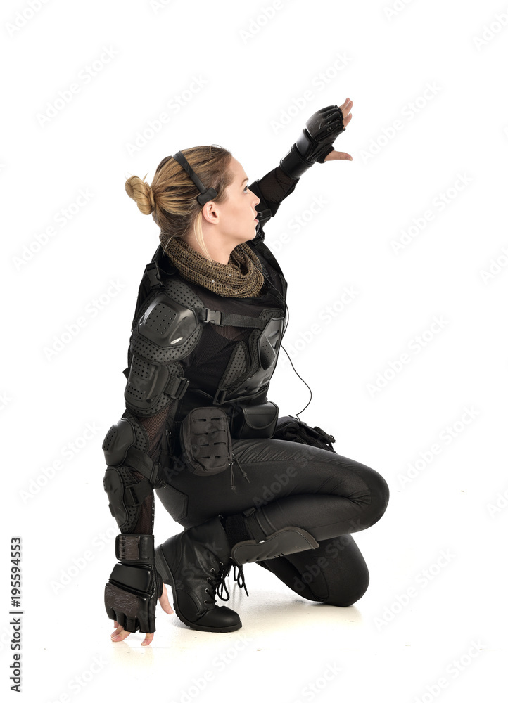full length portrait of female soldier wearing black tactical armour ...