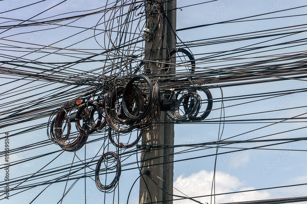 Messy wires attached to the electric mast. The chaos of cables and ...