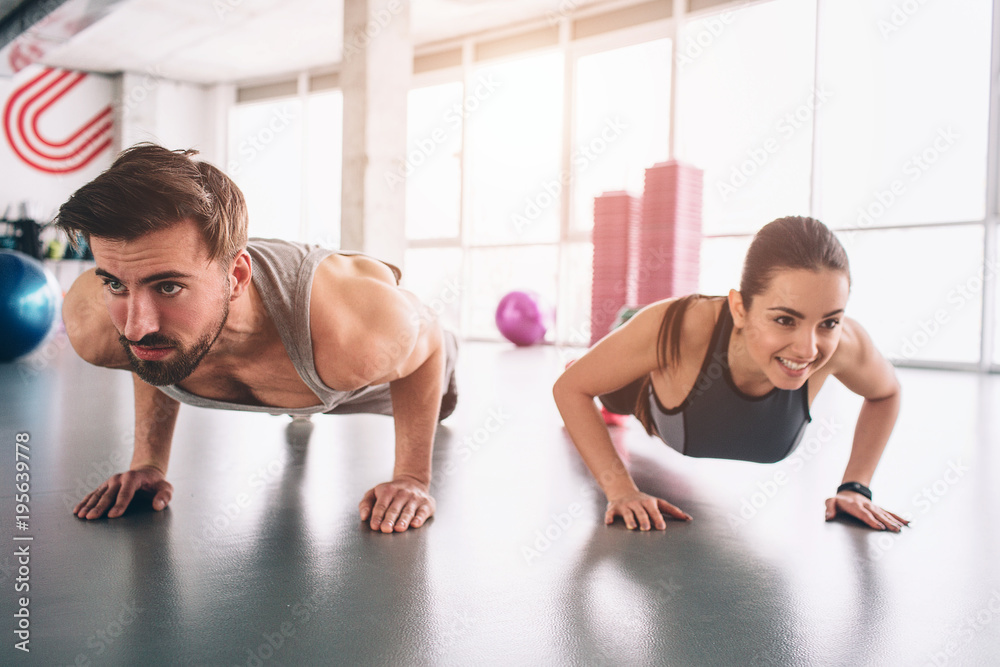 Another picture of two people standing in a low plank exercise and ...