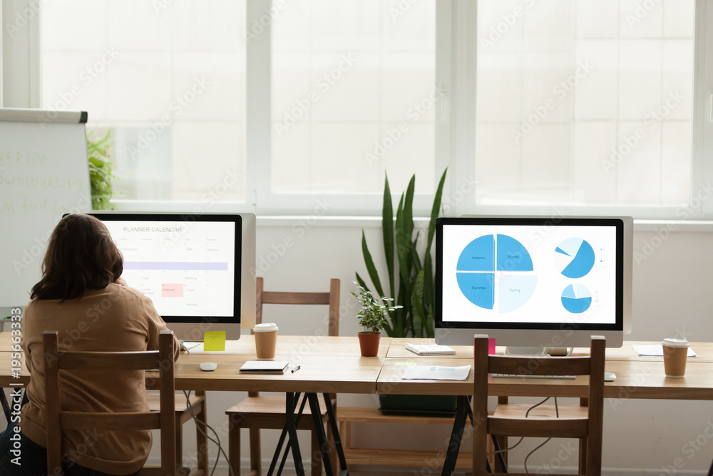 Modern office coworking space with woman working alone on computer, co ...