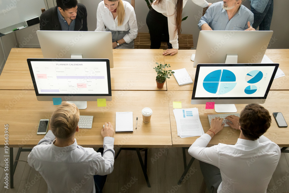 Male employees using computers for planning and data analysis sharing ...