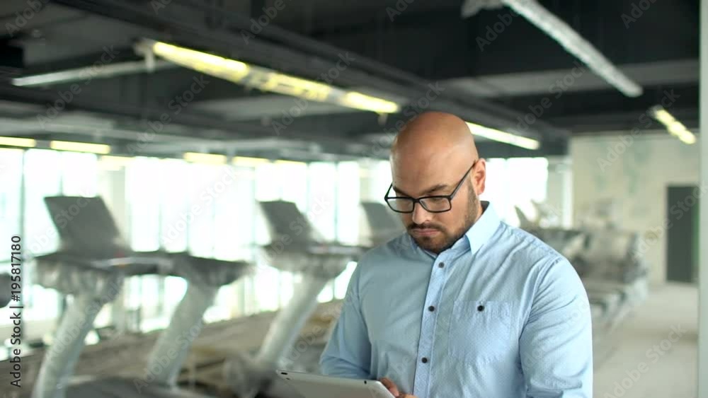 the owner of a sports club. portrait jf the owner gym. many simulators ...