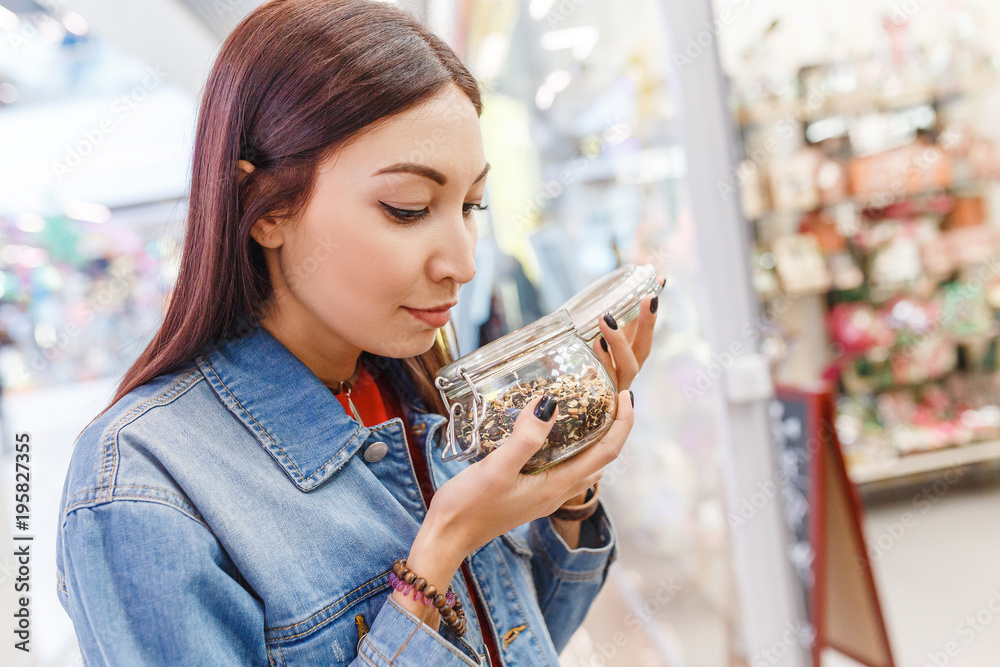 Positive woman customer choosing and smelling delicious flavor tea in ...