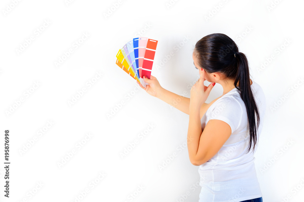 the girl with a thoughtful look chooses the color of the paint to ...