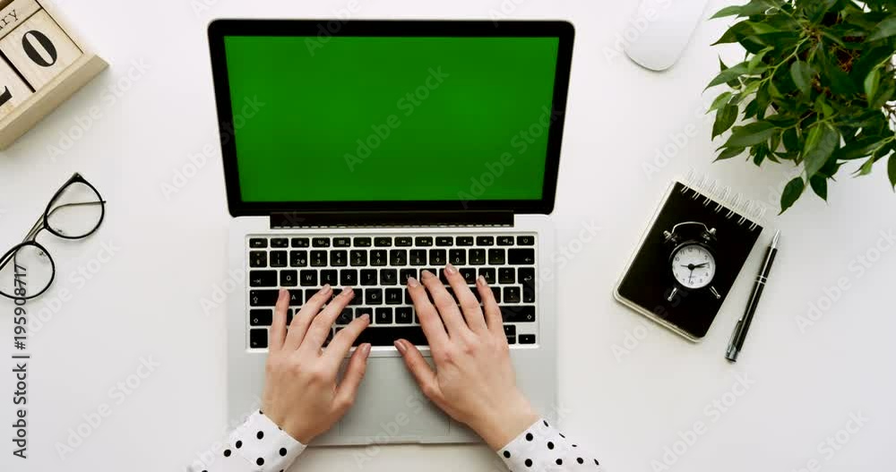 Top view on the office table with laptop computer with green screen and ...