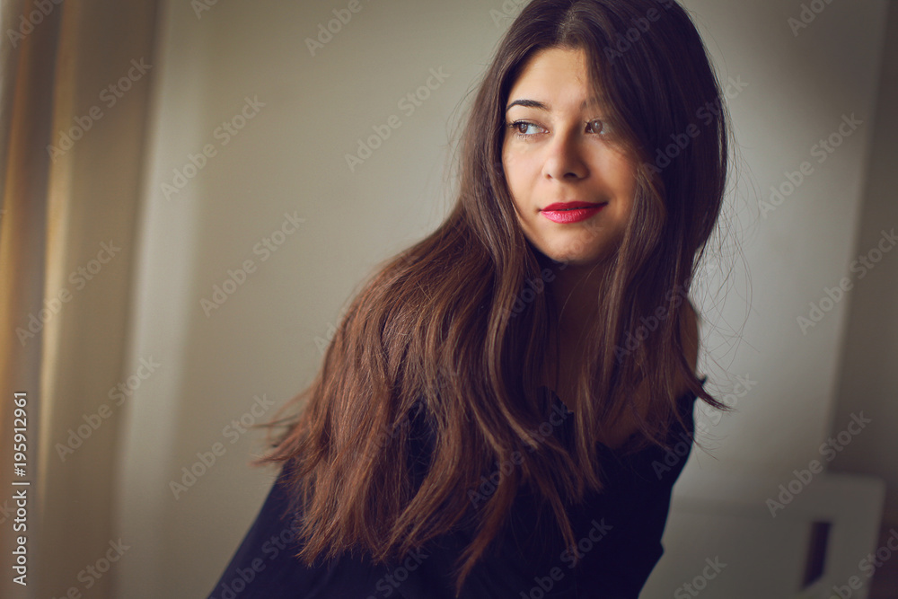 young beautiful cozy woman sits in the bedroom and smiles, female ...