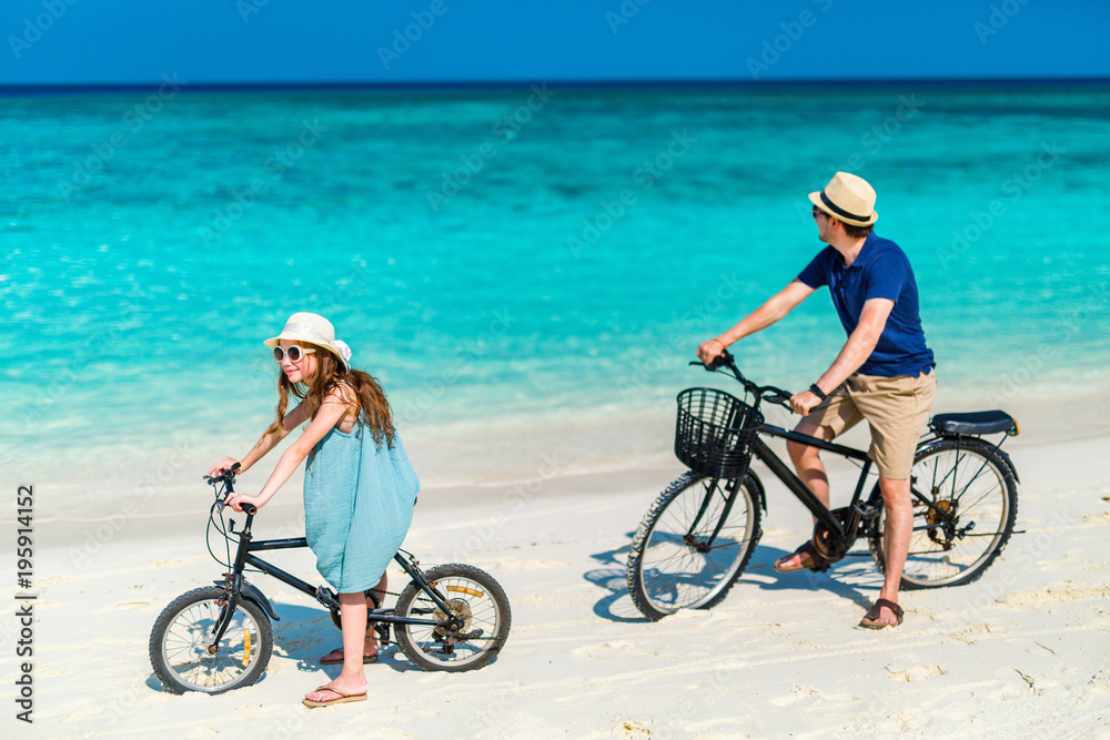 Father and daughter riding bikes at tropical beach Stock Photo | Adobe ...