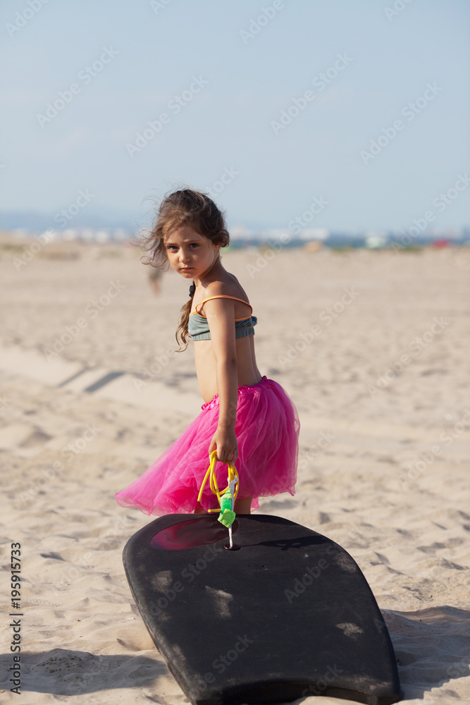 Little girl on the beach with a surfboard Stock Photo | Adobe Stock