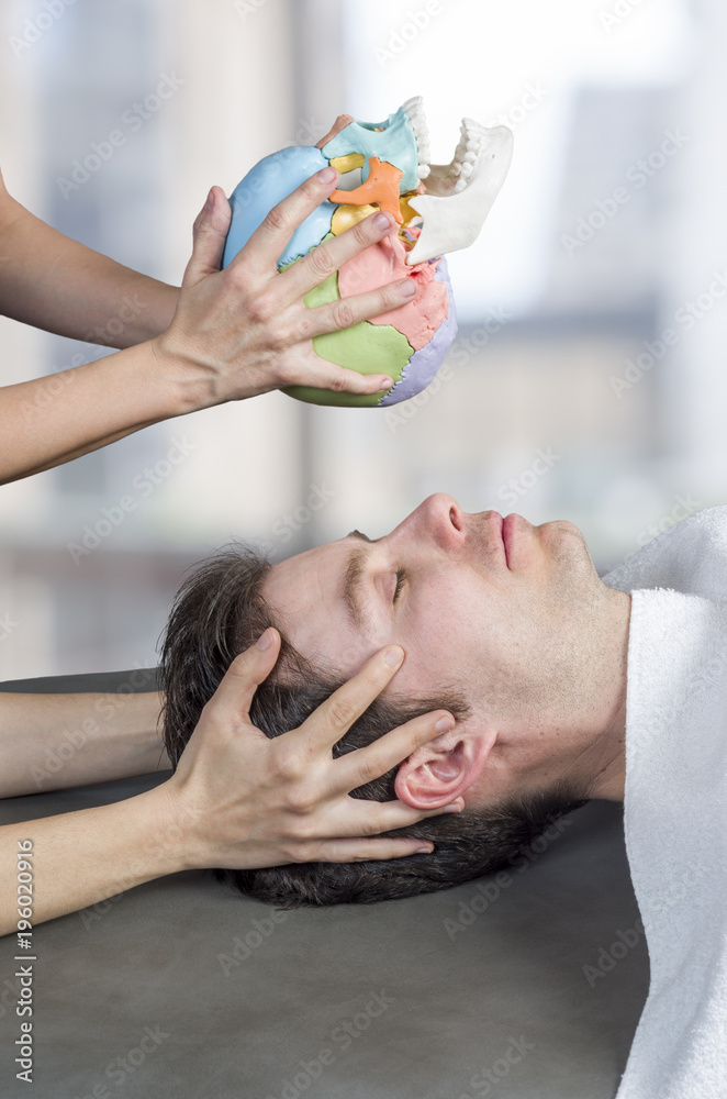 Physiotherapist doing a cranial sacral therapy to a man patient and ...