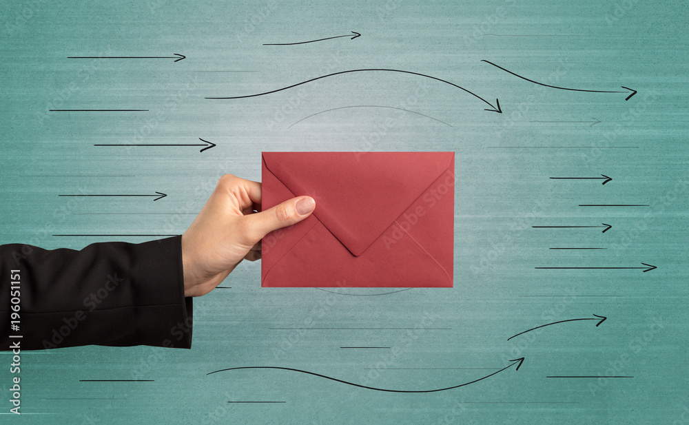 Hand holding envelope with arrows around Stock Photo | Adobe Stock