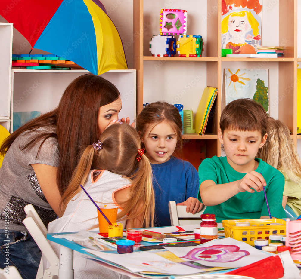Small students with teacher finger painting in art school class. Break ...