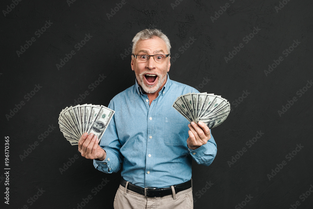 Image of joyful adult man 60s with gray hair holding money two fans of ...