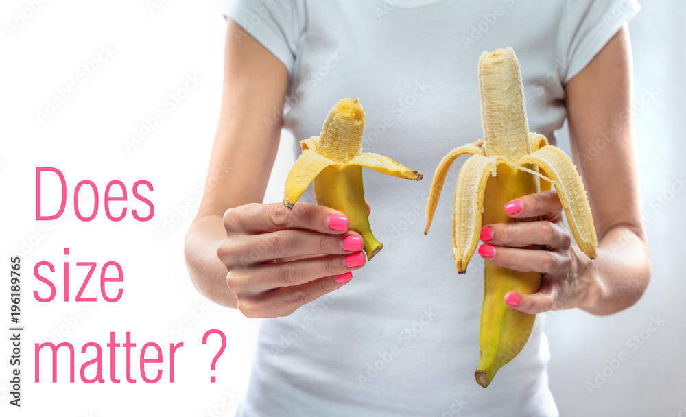 Bananas of different sizes in the hands of a slender girl. Concept ...