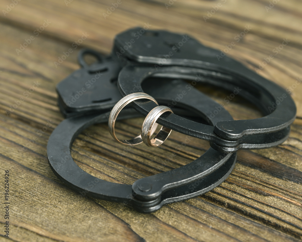 handcuffs and two wedding gold rings, bound. Against the backdrop of a ...