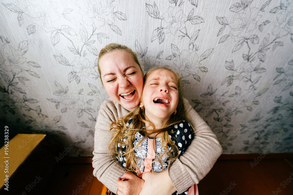 Young mother with child beautiful girl crying and laughing together ...