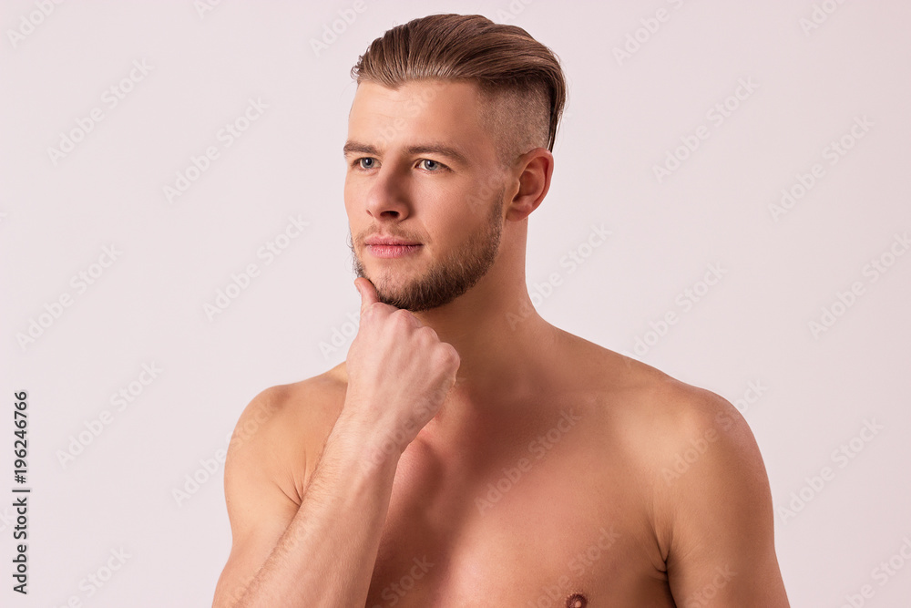 Portrait of attractive bearded man touching chin with hand and looking ...