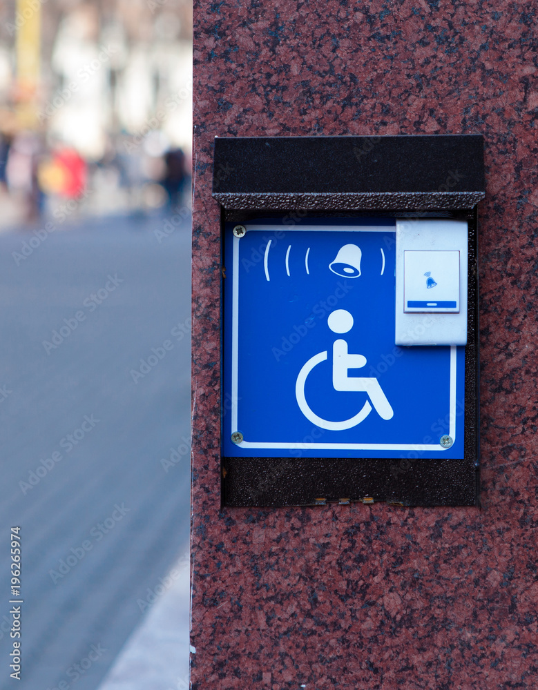 Handicapped access entrance pad mounted to a wall. Sign a button for a ...