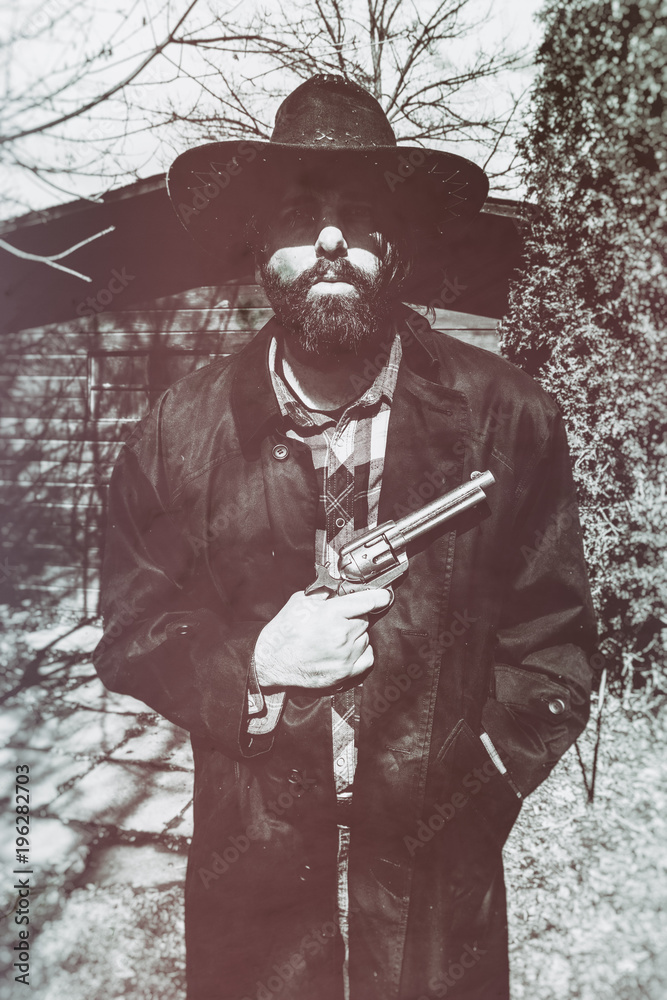 Cowboy standing outside with a gun. Old west, western style. Stock ...