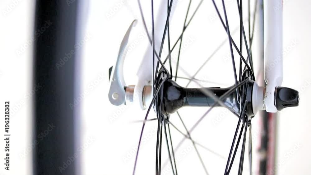 Vidéo Stock The front wheel of the bicycle rotates quickly on a white ...