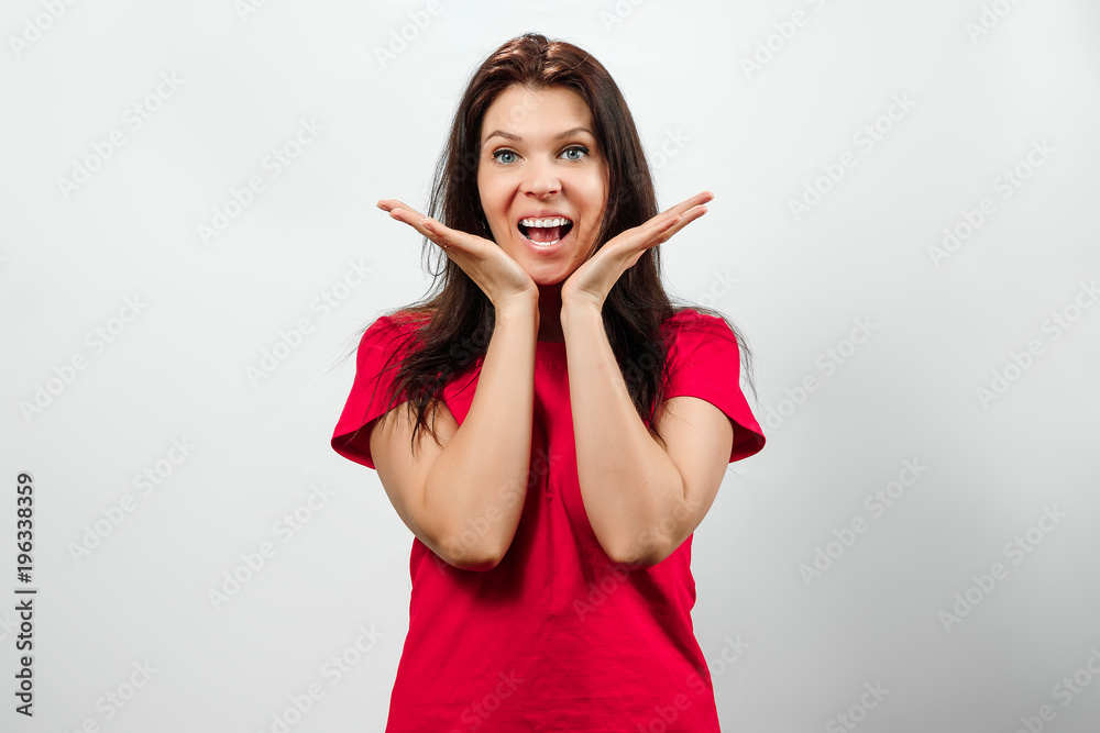 A young, beautiful girl shows an emotion of surprise. Isolated on a ...