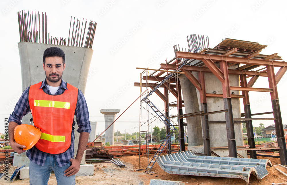 Civil engineer holding a helmet on a large bridge under construction ...