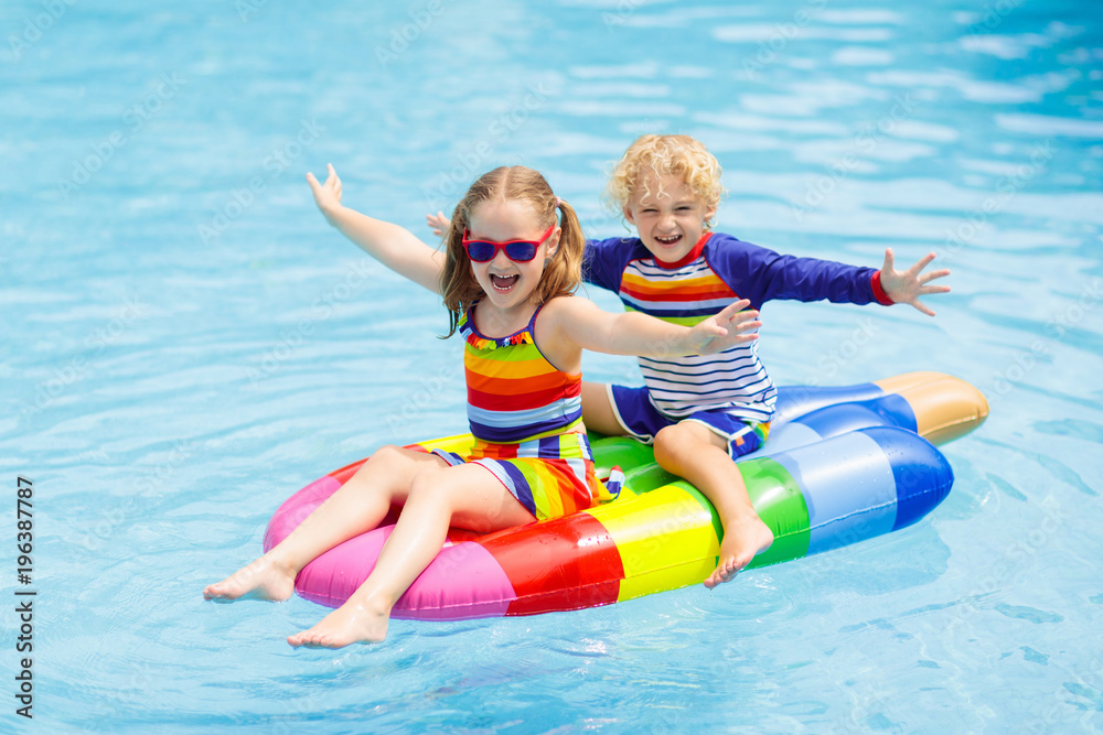 Kids on inflatable float in swimming pool. Stock Photo | Adobe Stock