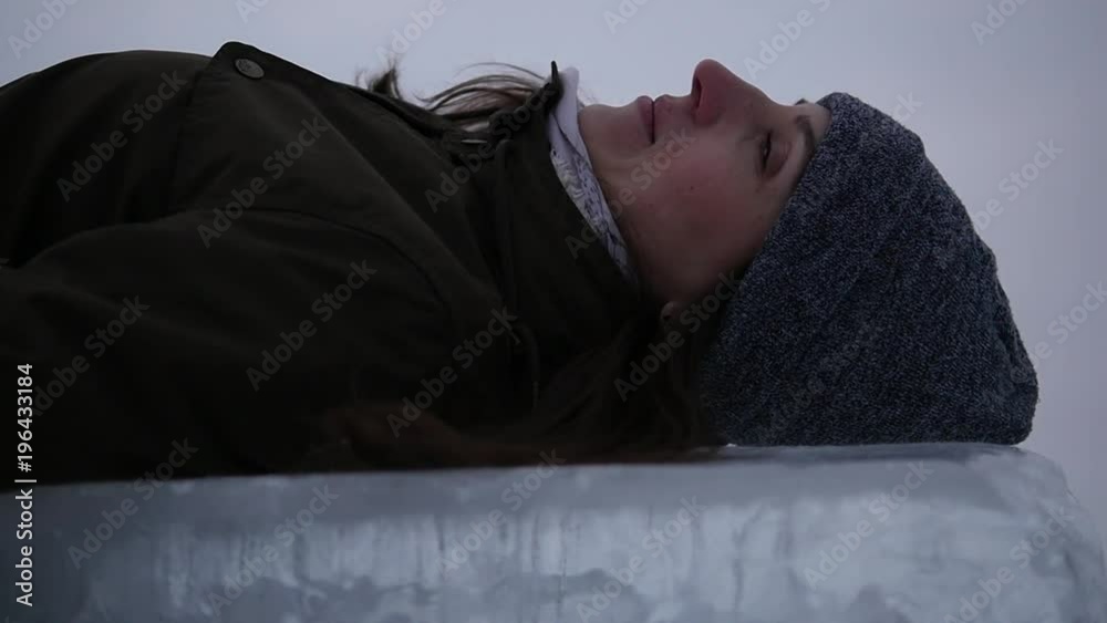 Young girl lies on ice in winter Stock Video | Adobe Stock