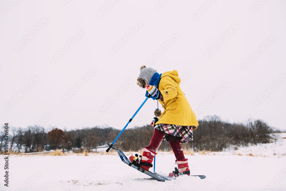 Girl snowshoeing in rural landscape Stock Photo | Adobe Stock