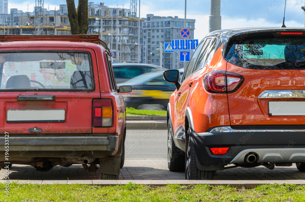 Rear view of two cars of different eras standing side by side in the ...