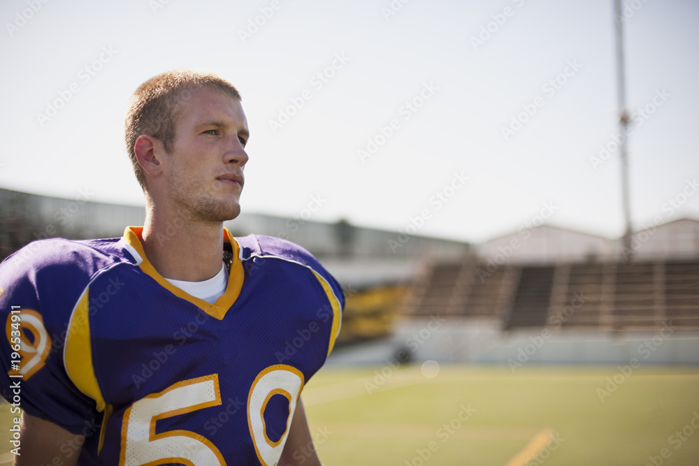 Football player looking away while standing on field Stock Photo ...