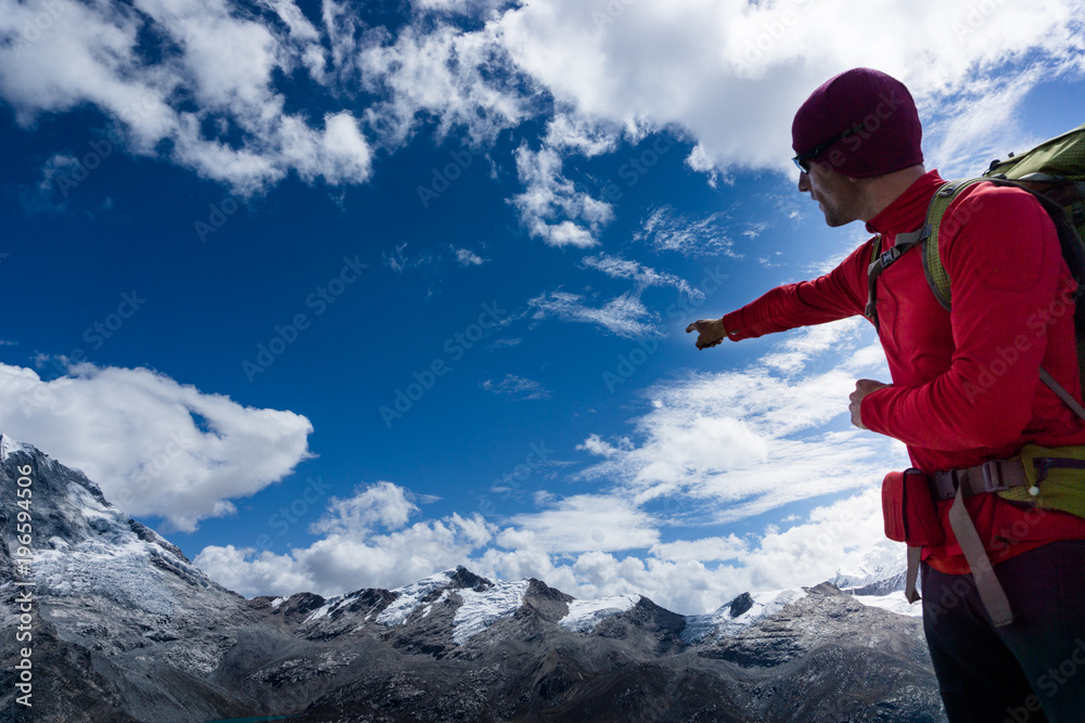 male mountain climber in a red shirt pointing to and explaining the ...