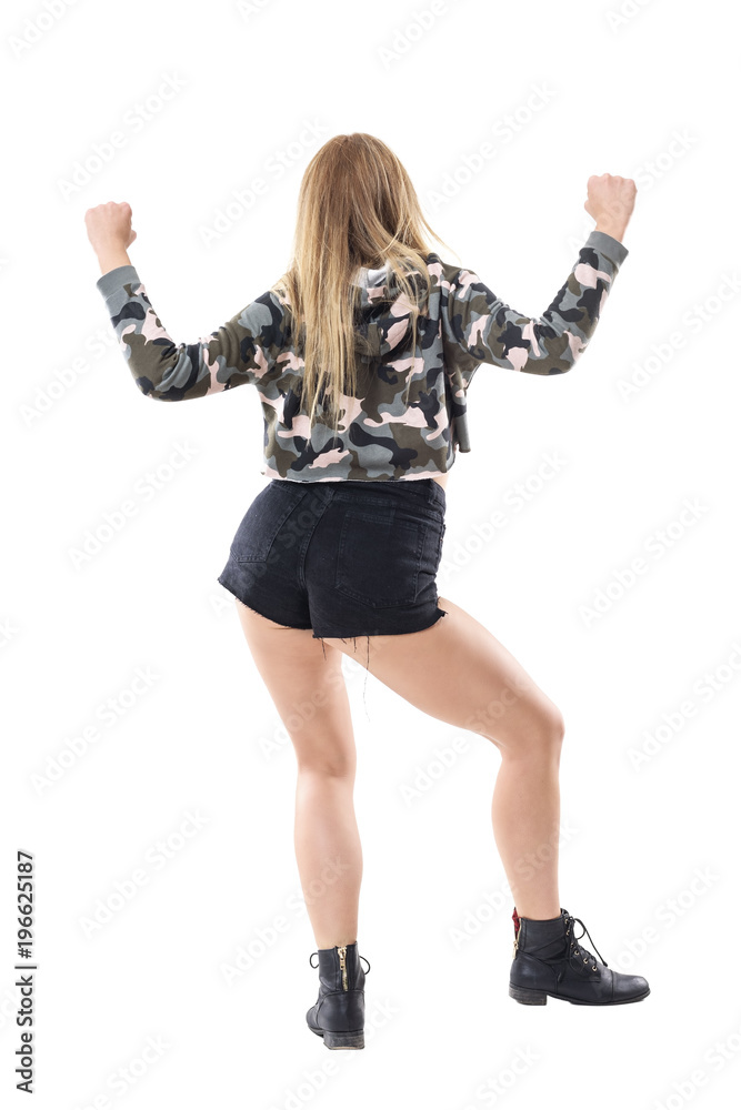 Back view of strong blonde woman in military camouflage jacket with ...