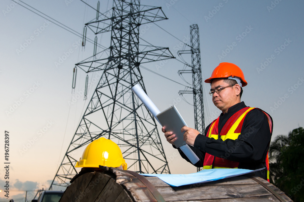 Electrical engineer working. Electrician holding blueprint and tablet ...