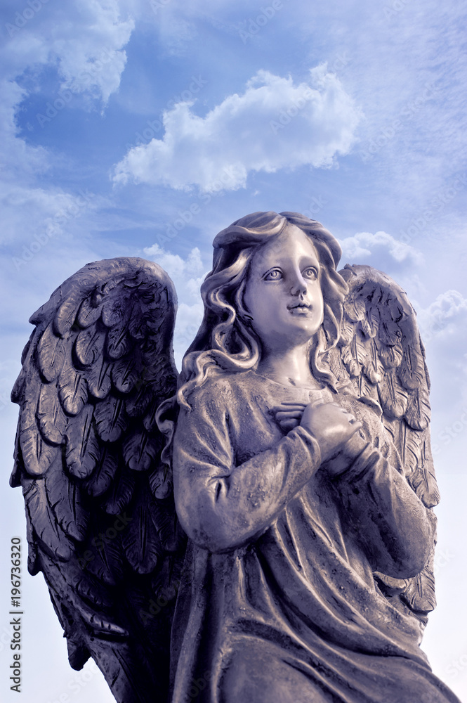 Angel archangel Gabriel or Haniel in praying gesture over blue sky ...