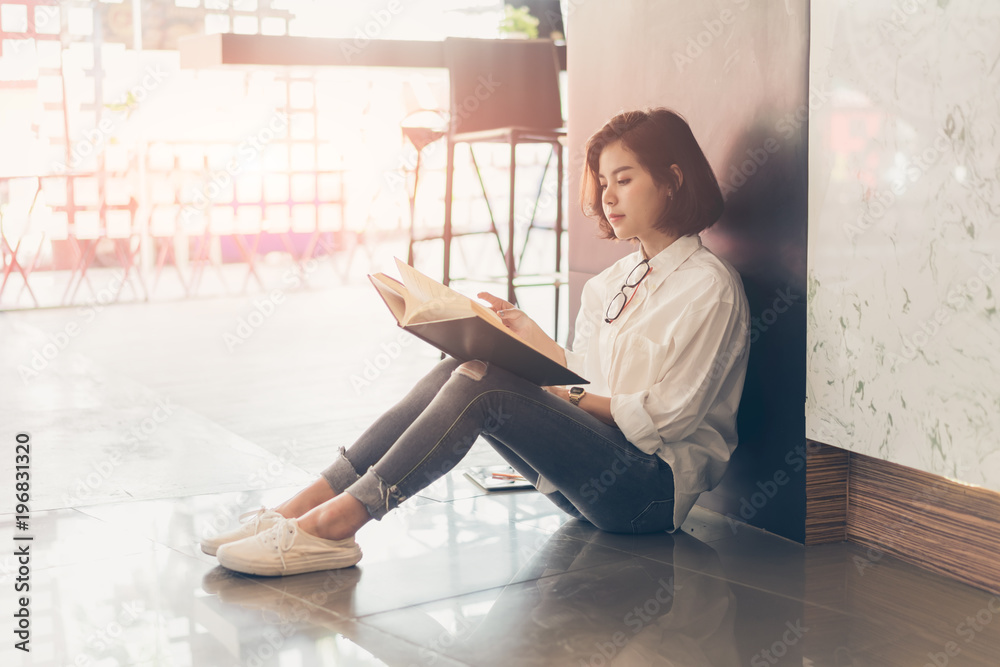Sad and depressed women sitting at walkway and reading a book with ...