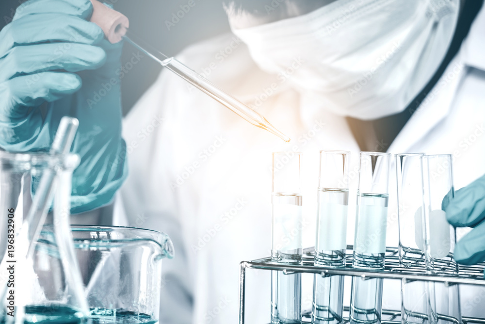 Scientist dropping chemical liquid to flask in lab Glass laboratory ...