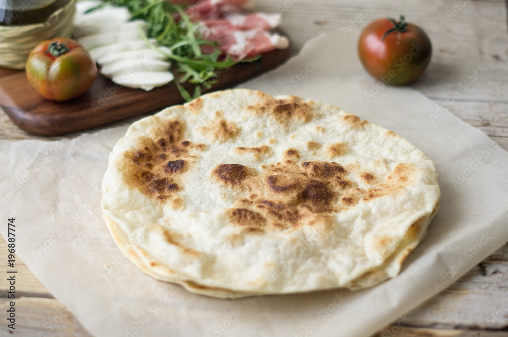 Homemade Italian flatbread called piadina with rocket salad, prosciutto ...