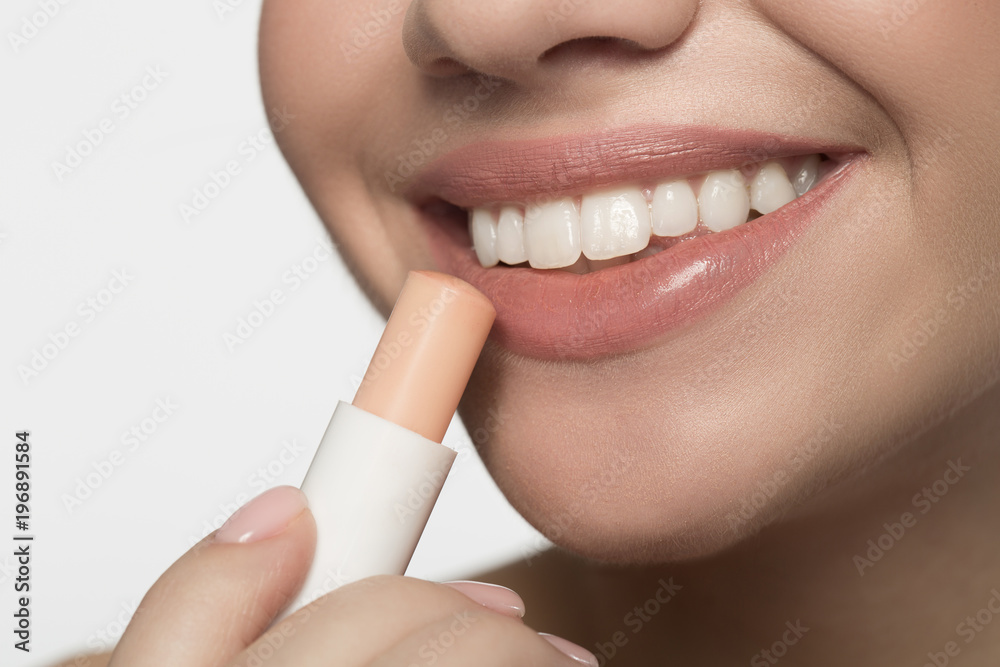 Close up of mouth of cute girl is caring of her lips by special ...
