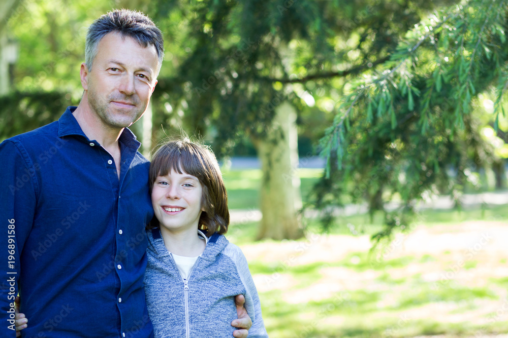 Handsome middle-aged man in park with his son. Attractive mid adult ...