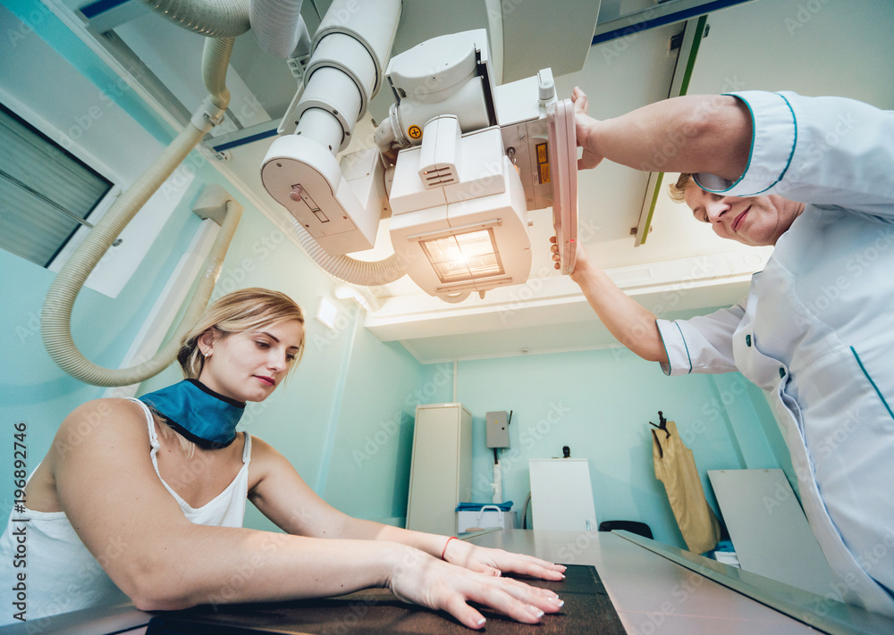 Radiologist and patient in a x-ray room. Classic ceiling-mounted x-ray ...