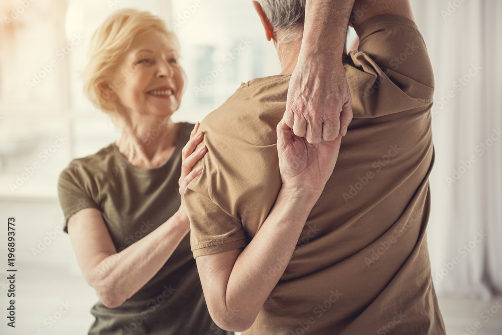 Athletic retiree holding his hands hooked behind his back, standing ...
