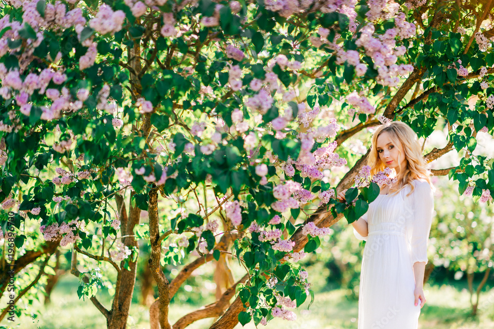 Fine art portrait of young blonde girl in white elegant dress in summer ...