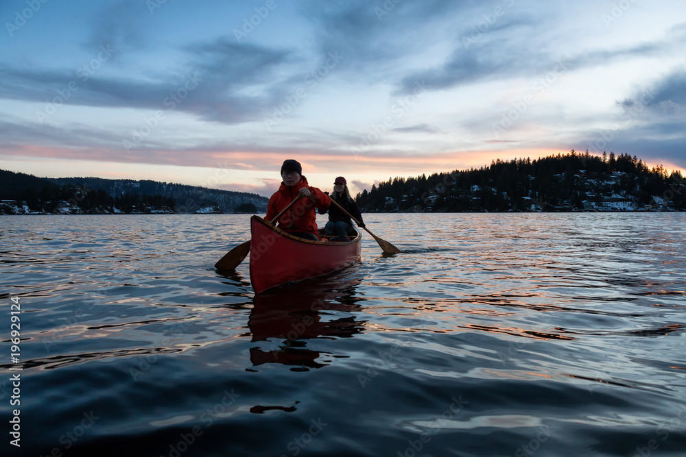 Couple friends on a wooden canoe are paddling in an inlet surrounded by ...