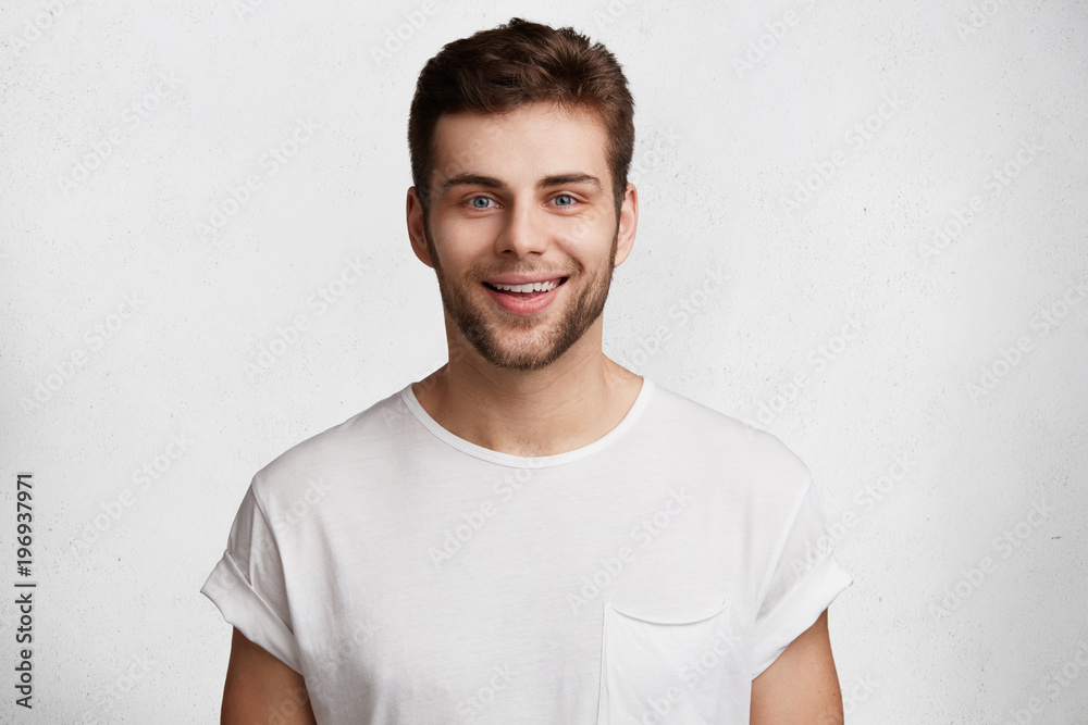 Horizontal shot of handsome young guy with blue eyes and bristle, has ...